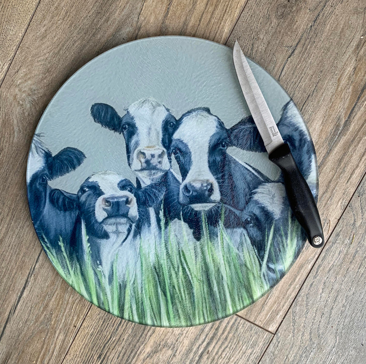 Friesian Cows Through Grass Round Worktop Saver – Grace Scott Art